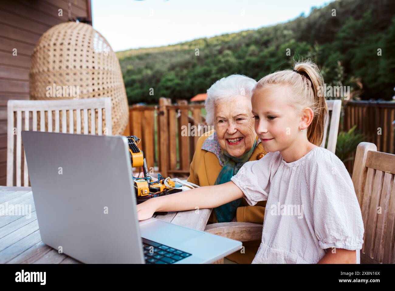 Grandmother supporting granddaughter in robotics, science, IT ...