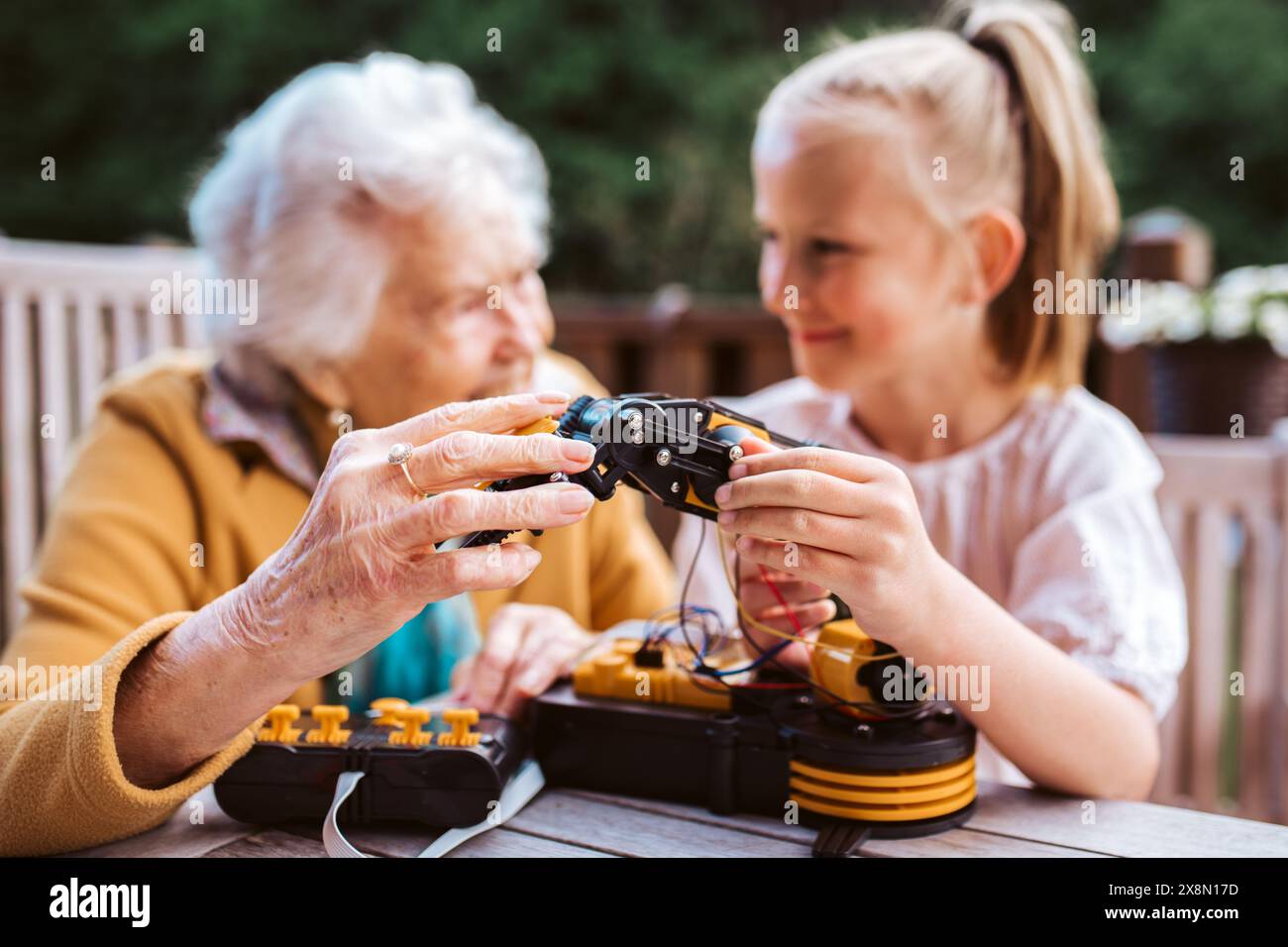Grandmother supporting granddaughter in robotics, science, IT ...