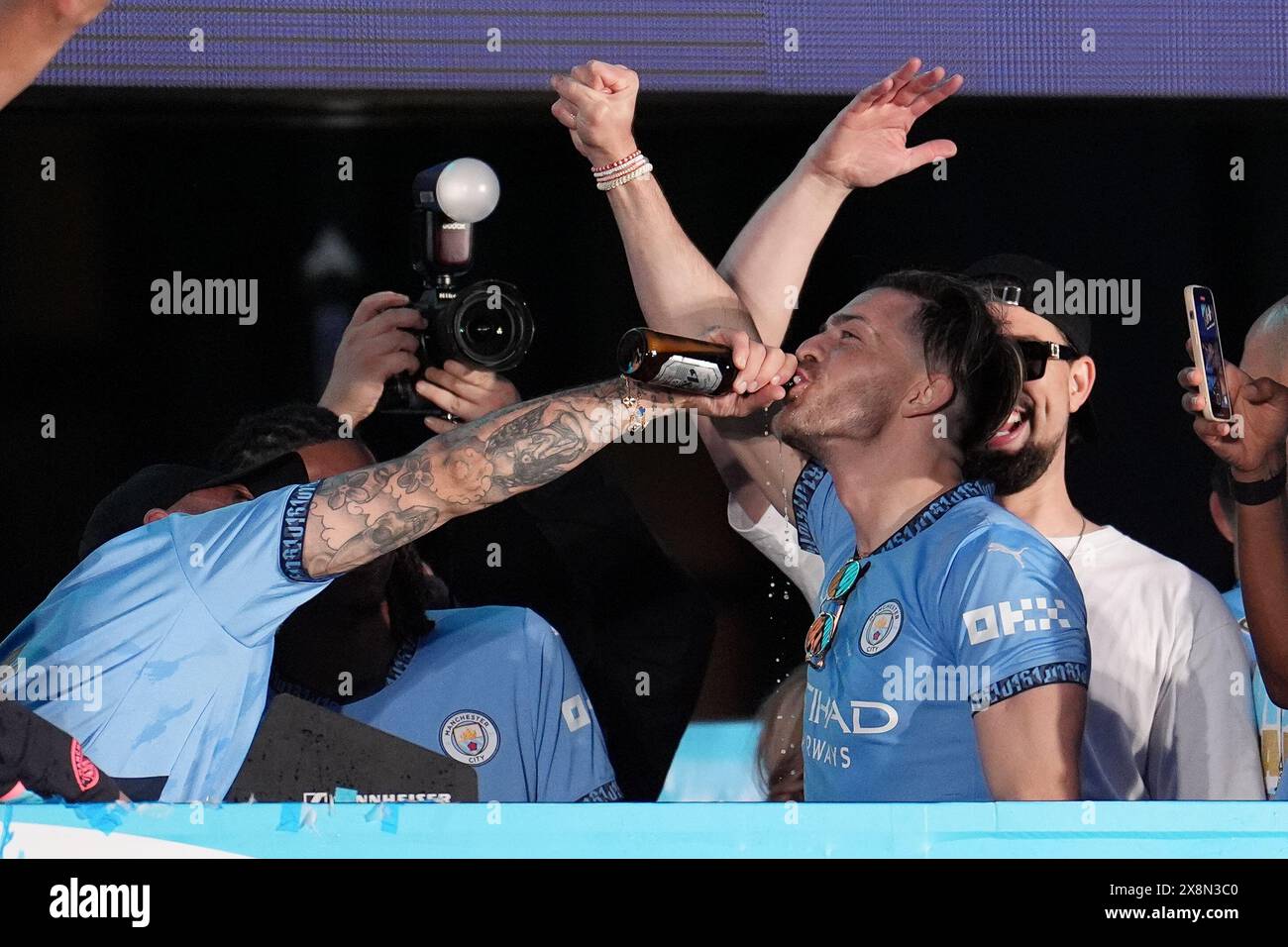 Manchester City's Jack Grealish (centre) takes a drink from Kyle Walker ...