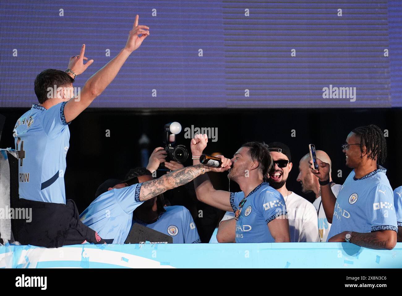 Manchester City's Jack Grealish (centre) takes a drink from Kyle Walker ...