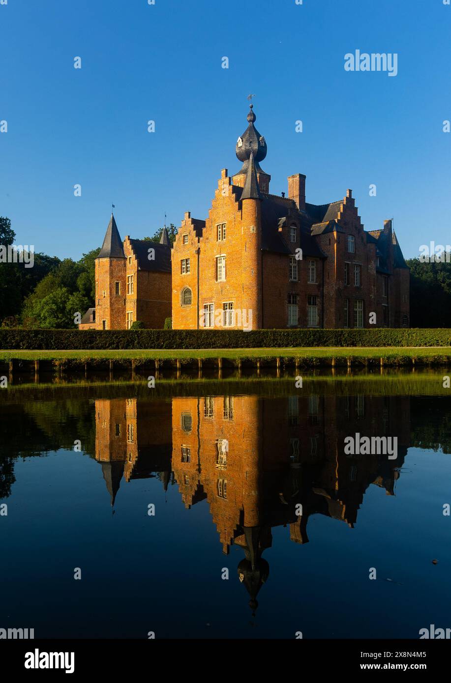 Medieval castle in Flemish town of Rumbeke reflecting in water of pond ...