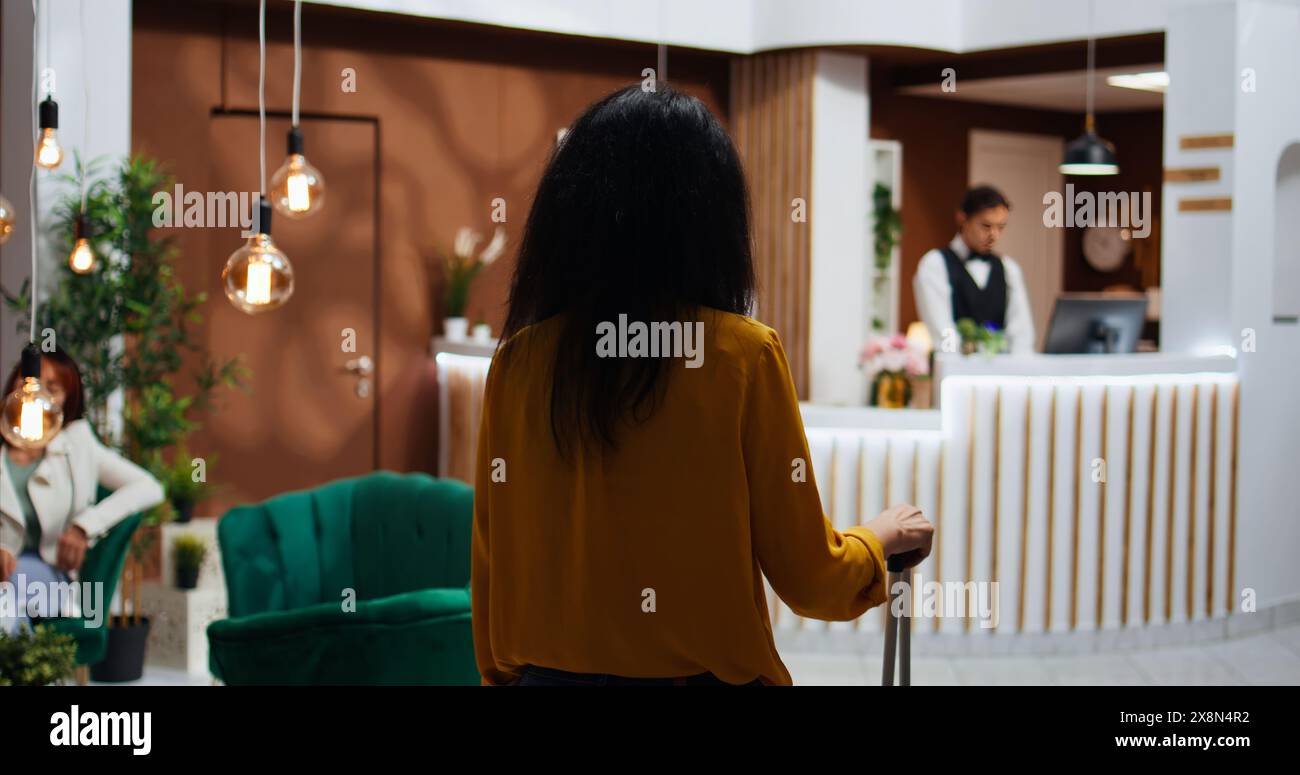 Hotel guest arriving early at reception after long flight, trying to do ...