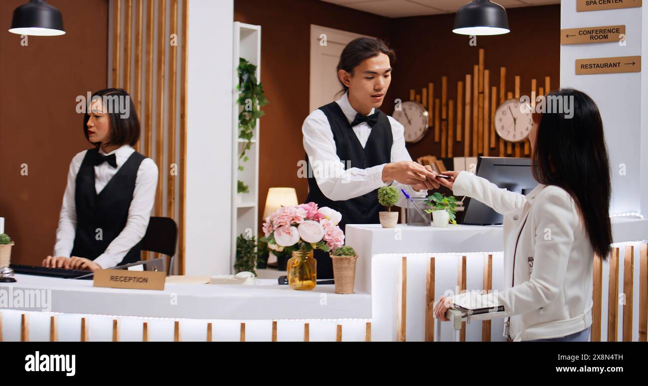 Hotel staff examines passport info for customer identification ...