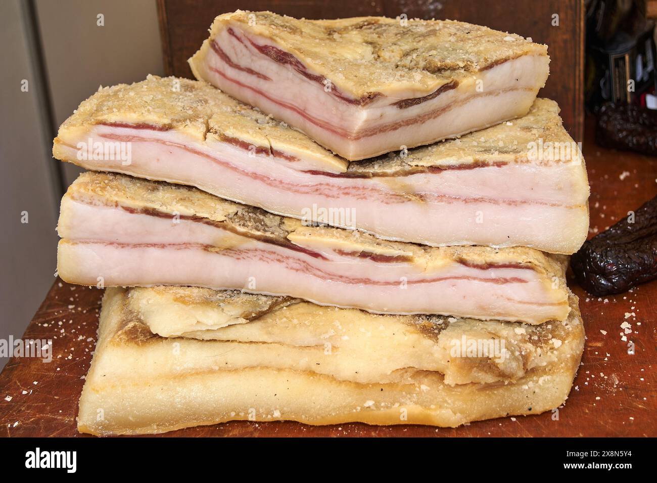 Detailed image of three slices of cured bacon stacked, showing the ...
