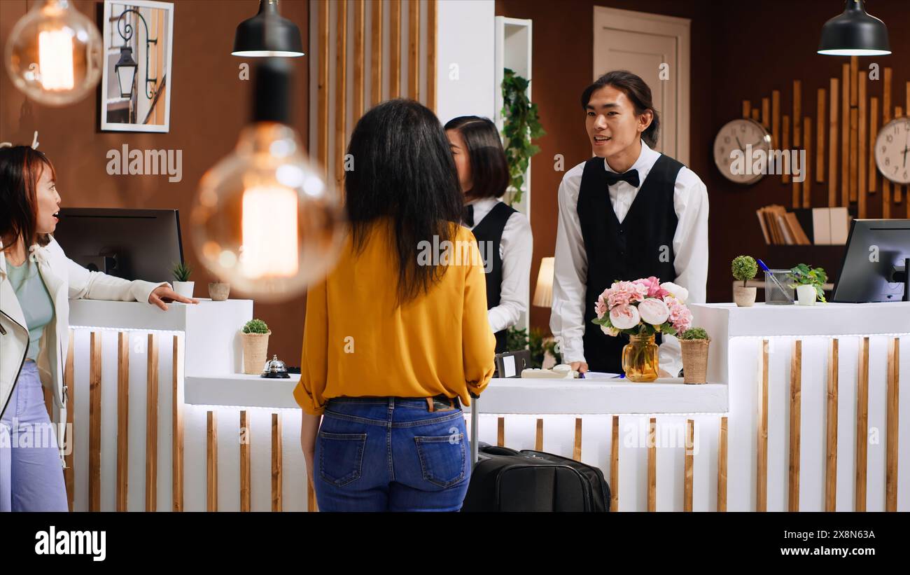 Hotel guests using service bell for assistance at front desk, calling ...