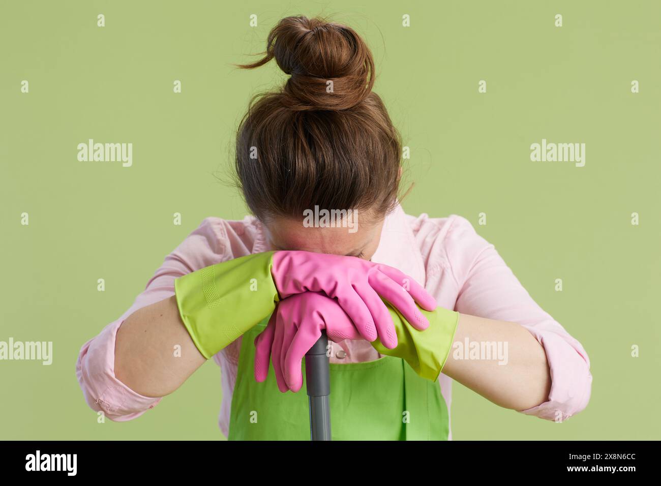 Spring cleaning. sad modern middle aged woman in green apron and rubber ...