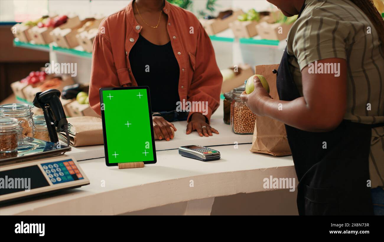 Tablet showing isolated greenscreen display at cash register, running ...