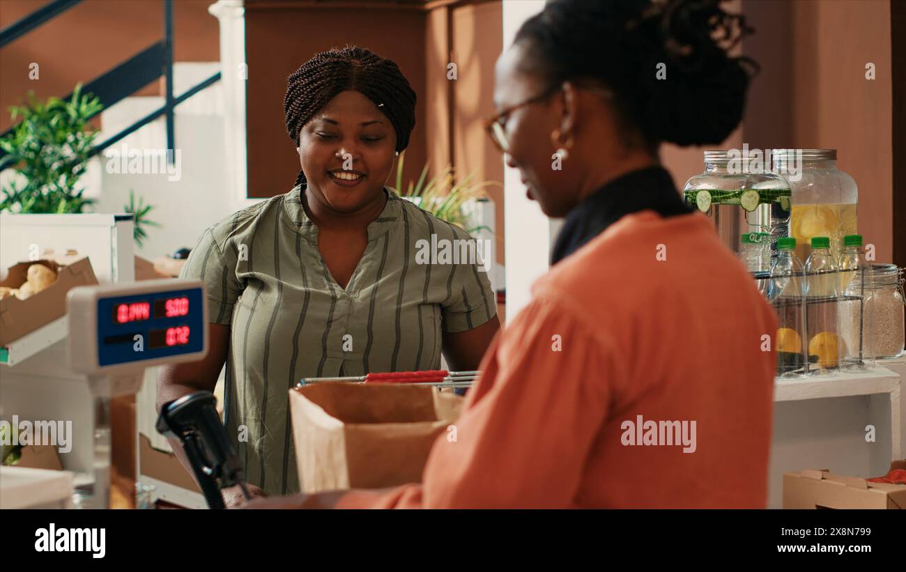 Merchant weighting fruits and veggies on scale for client, selling ...