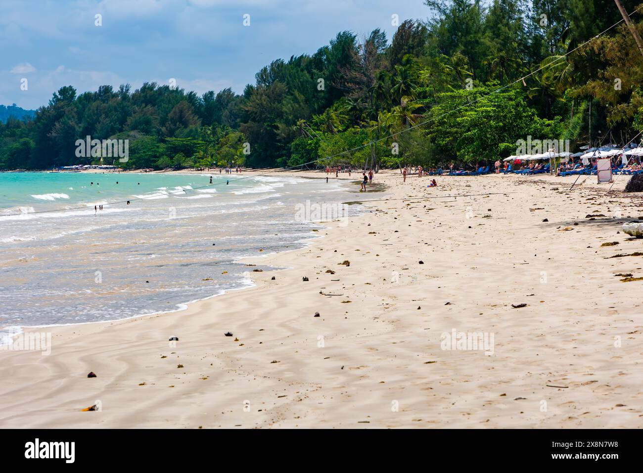 KHAO LAK, THAILAND - APRIL 04 2024: Tourists walking along a sandy ...