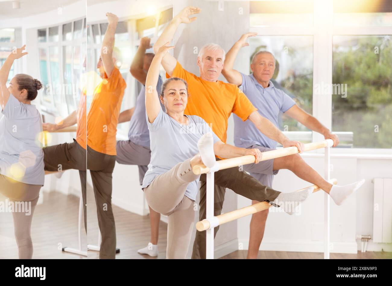 Ballet pose grand batman - elderly women and men at choreography lesson ...