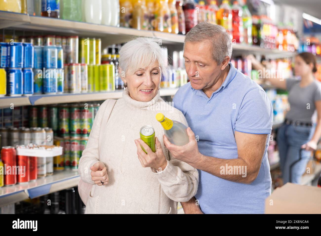 Man and woman purchasers choosing cool drink in supermarket Stock Photo ...