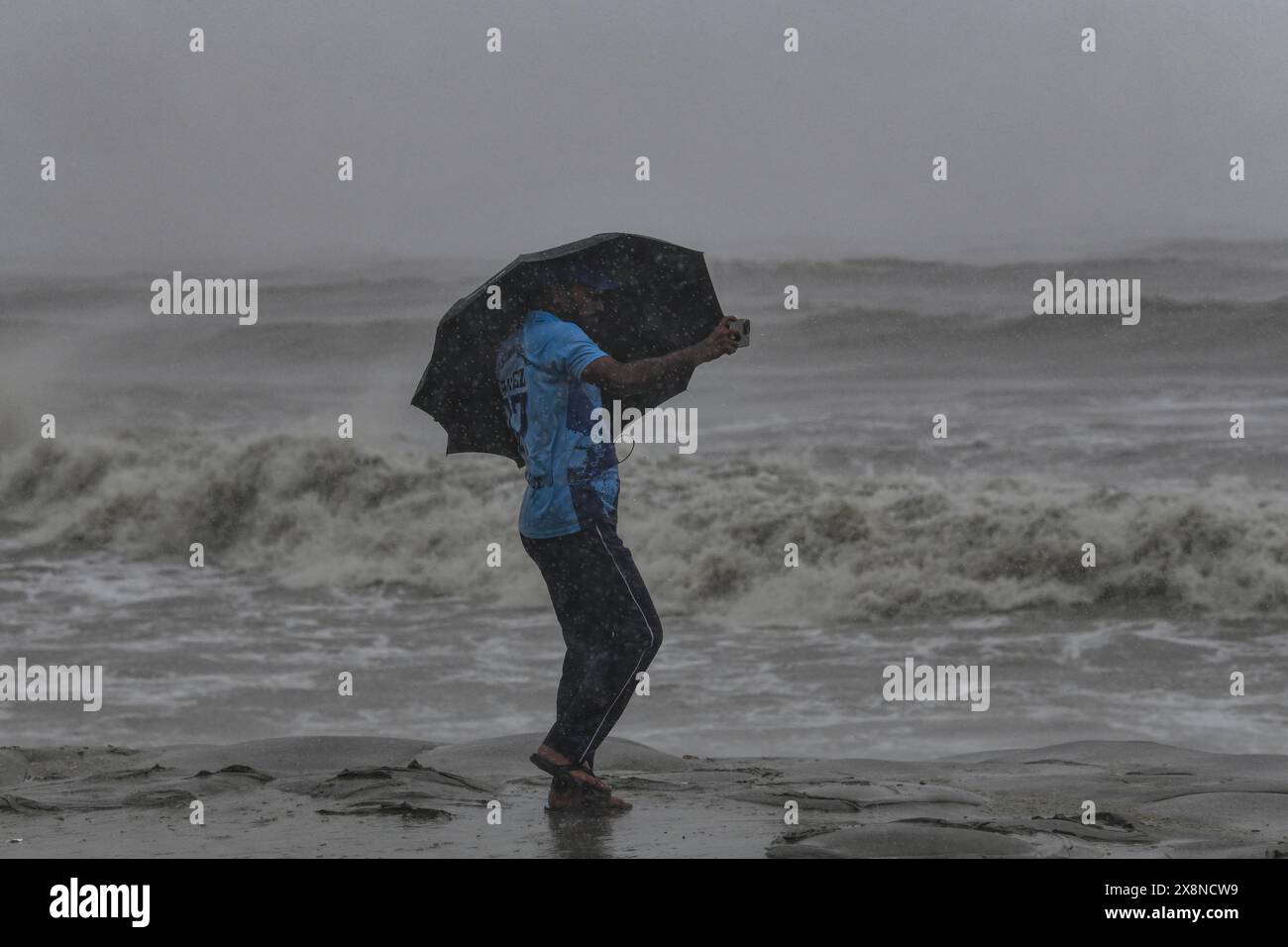 Dhaka, Bangladesh. 26th May, 2024. A man taking a picture at Kuakata ...