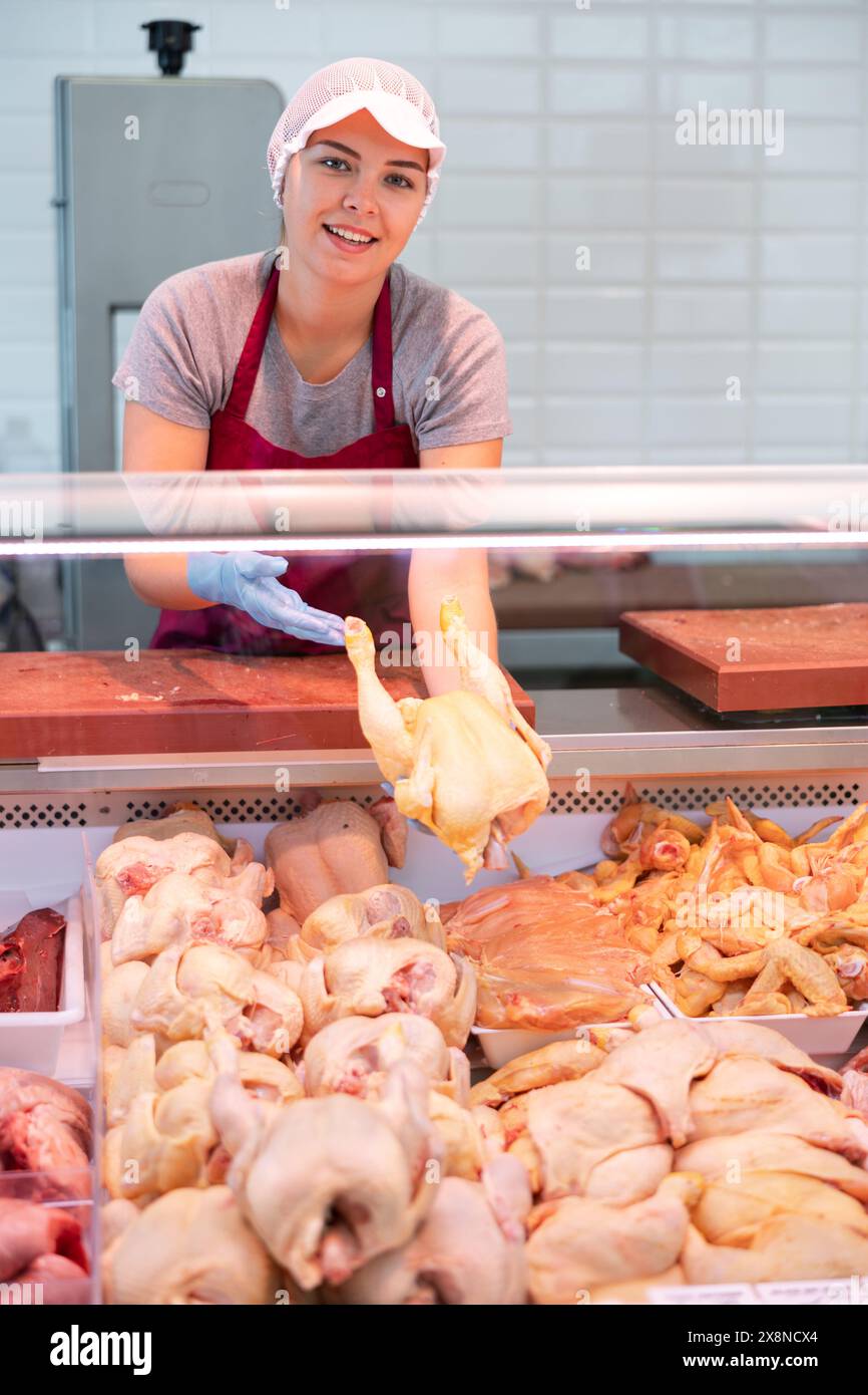 Young female butcher shop owner offering raw chickens Stock Photo - Alamy
