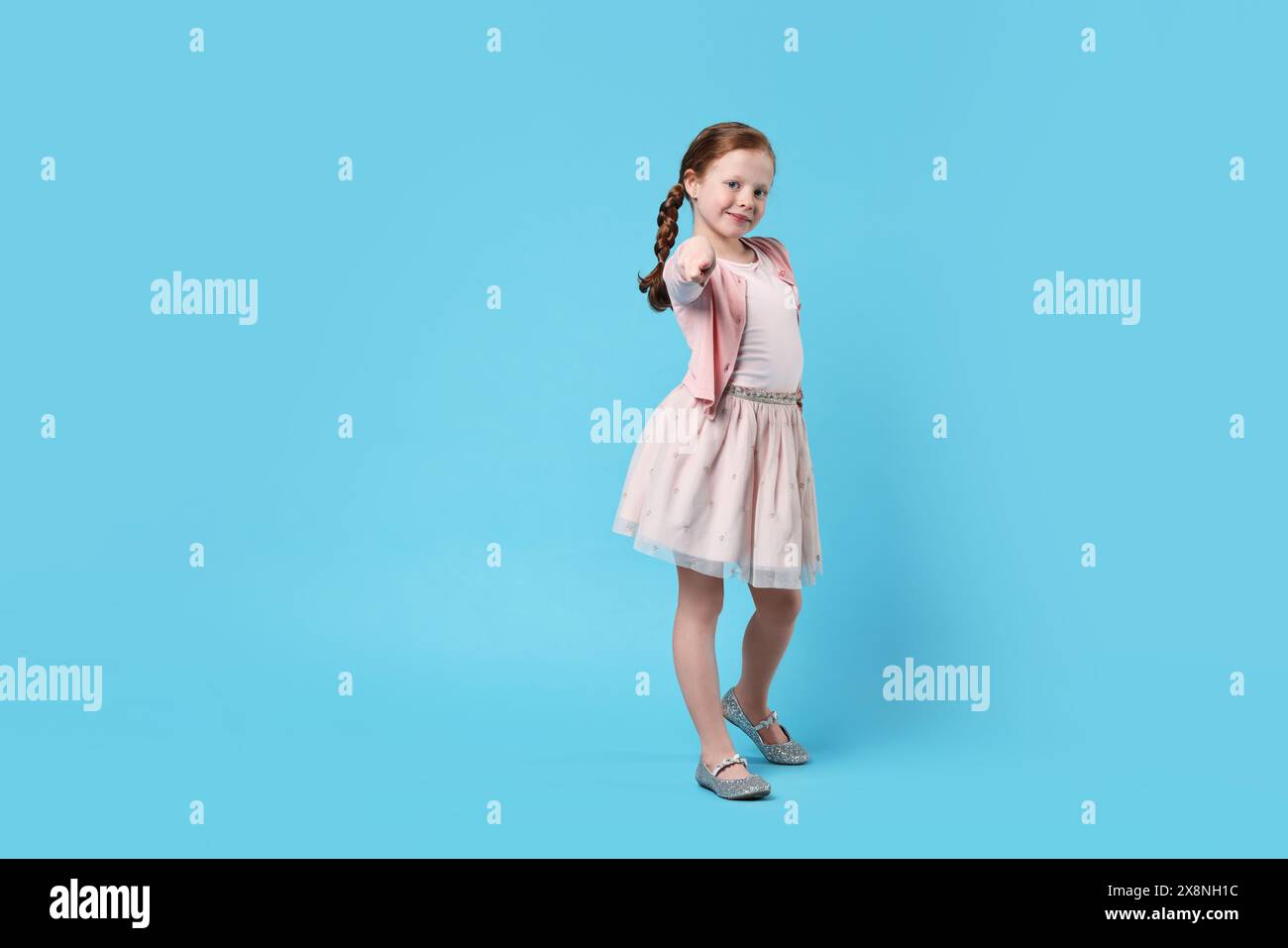 Cute little girl dancing on light blue background, space for text Stock ...