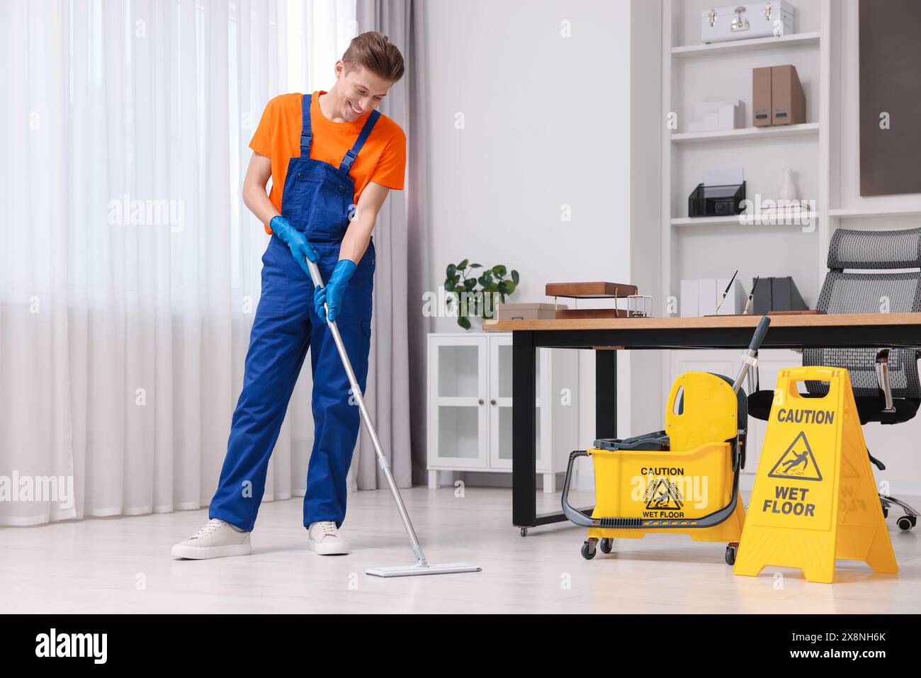 Cleaning service. Man washing floor with mop in office Stock Photo - Alamy