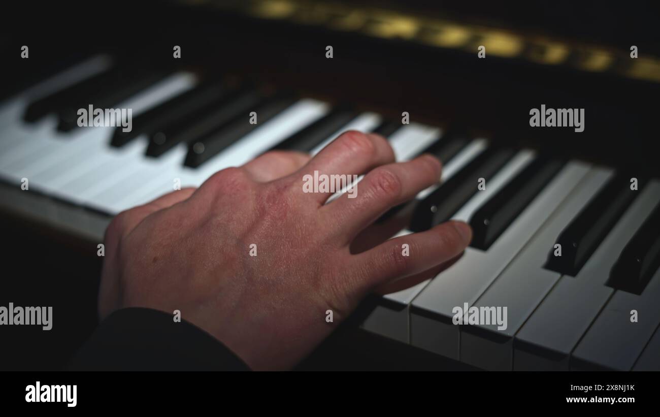 Close-up of hand playing piano. Media. Light falling on hand playing ...