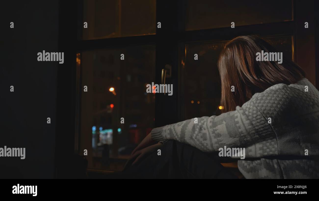 Rear view woman sitting sadly hi-res stock photography and images - Alamy