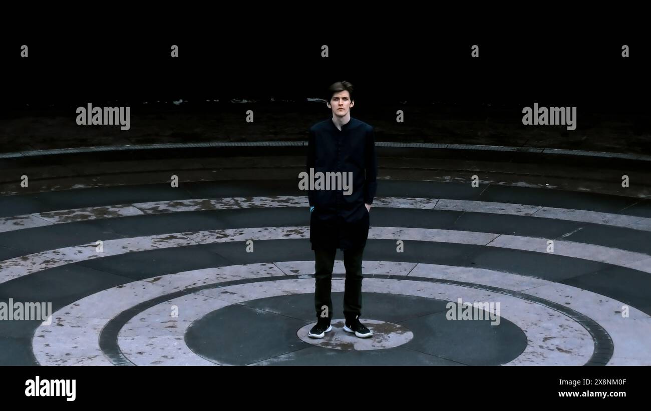 Tall man in black clothes standing in the meddle of amphitheater. Stock ...