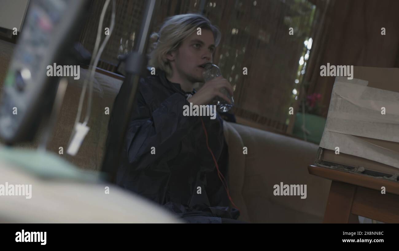 Man excitedly drinks bottle of water. Stock. Young man drinks bottle of ...