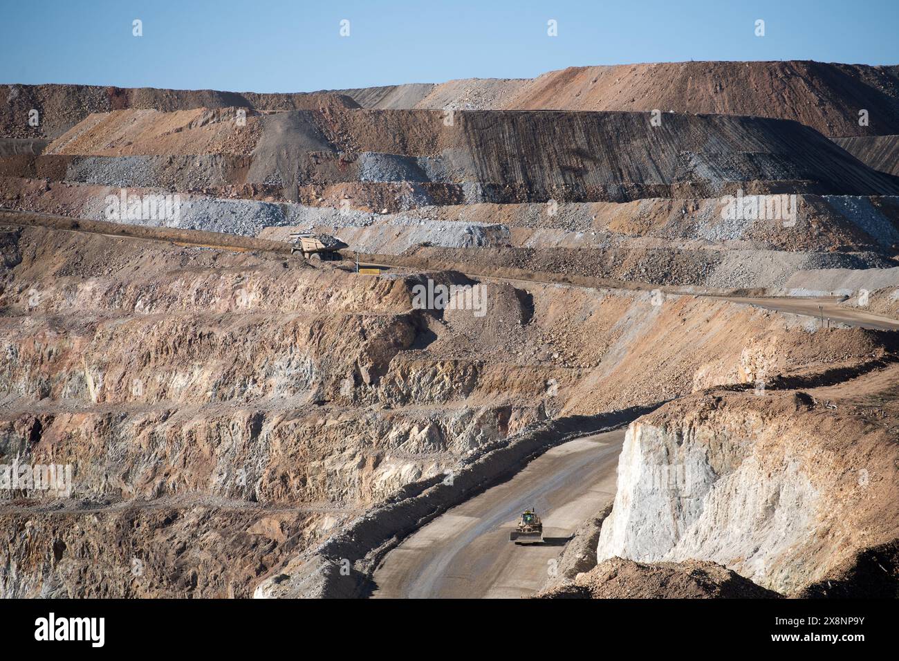 Huge ore trucks haul gold ore from the open pit mine to processing at ...