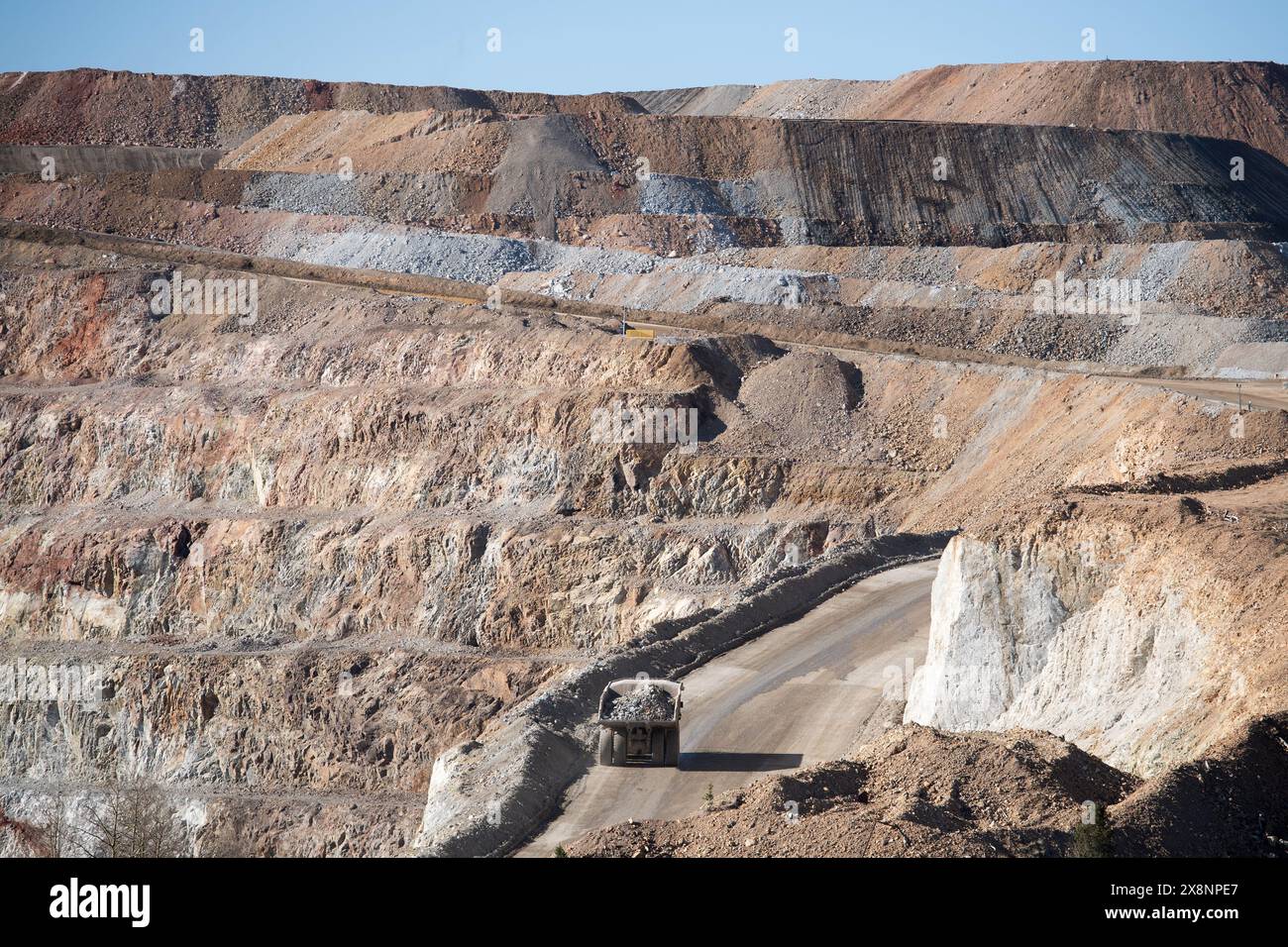 Huge ore trucks haul gold ore from the open pit mine to processing at ...