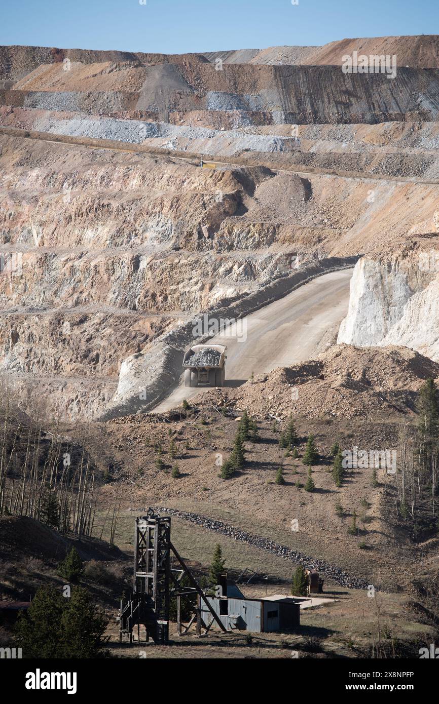 Huge ore trucks haul gold ore from the open pit mine to processing at ...