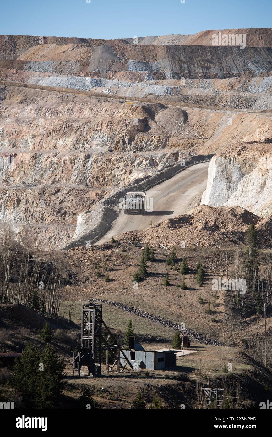 Huge ore trucks haul gold ore from the open pit mine to processing at ...