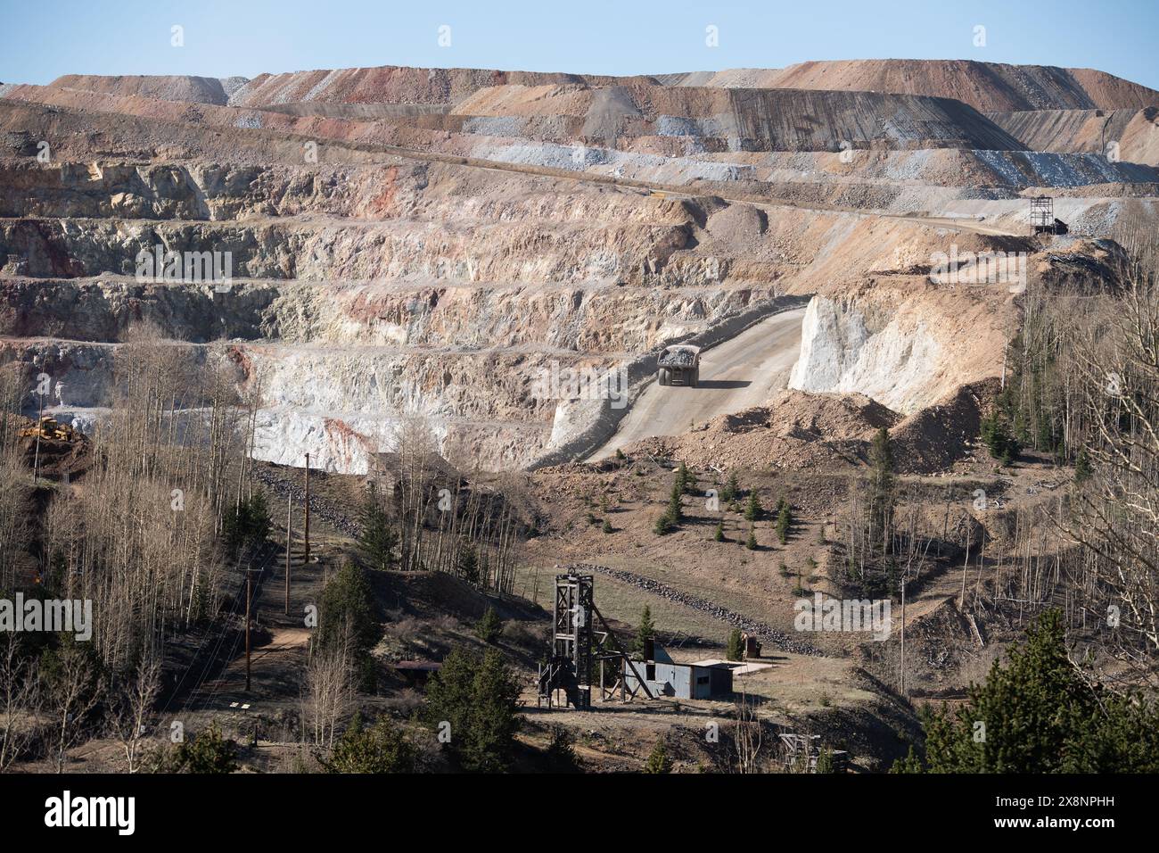 Huge ore trucks haul gold ore from the open pit mine to processing at ...