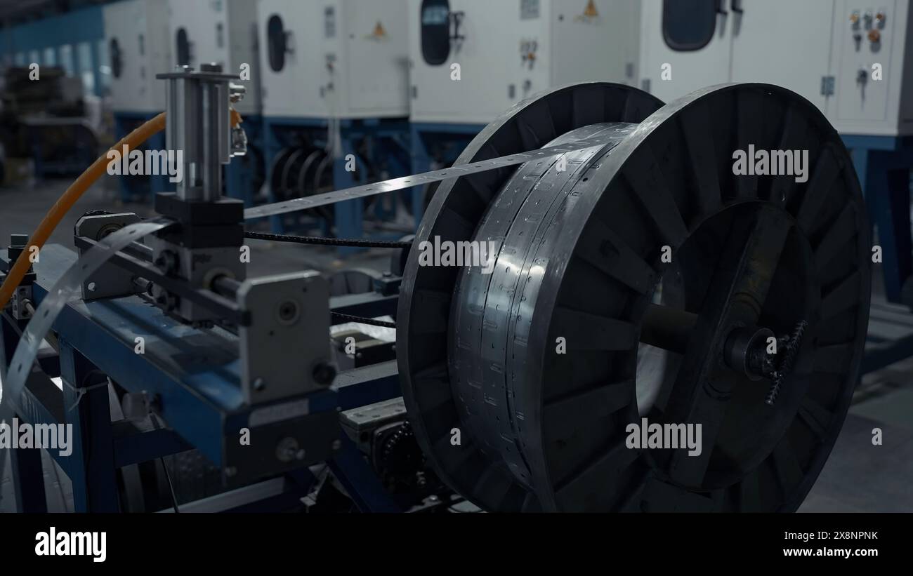 Metal long narrow sheets wraping on a bobbin. Creative. Large spool in ...