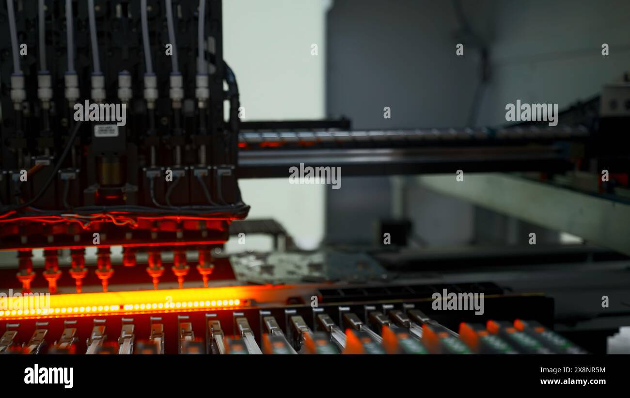 Factory machine at work: printed circuit board being assembled with ...
