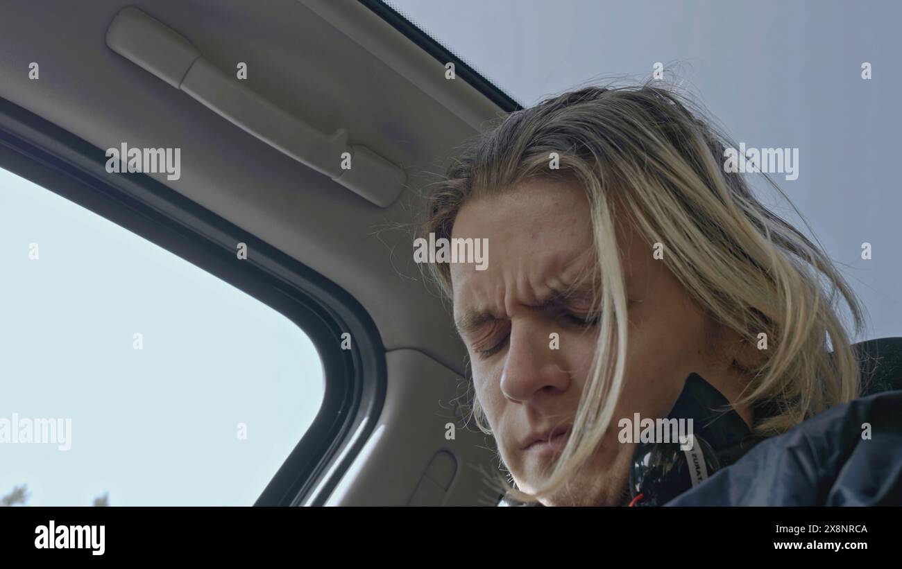 Close-up of young man sitting nervously in car. Stock. Man with panic ...