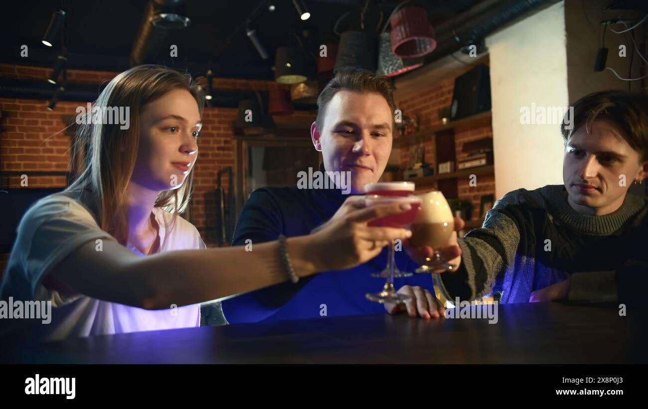 Group of friends are sitting at bar and drinking cocktails. Media ...