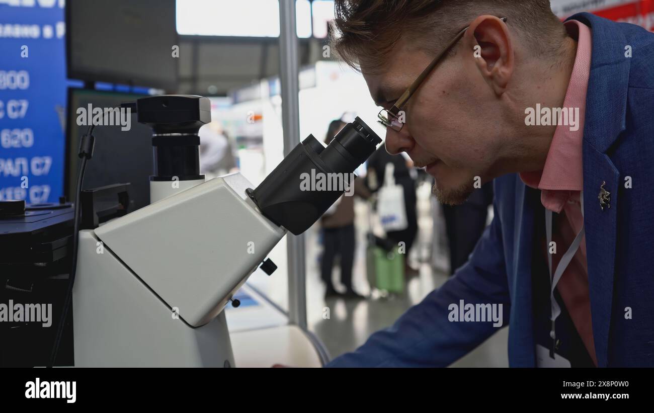 Man looks through microscope. Media. Man looks through new microscope ...