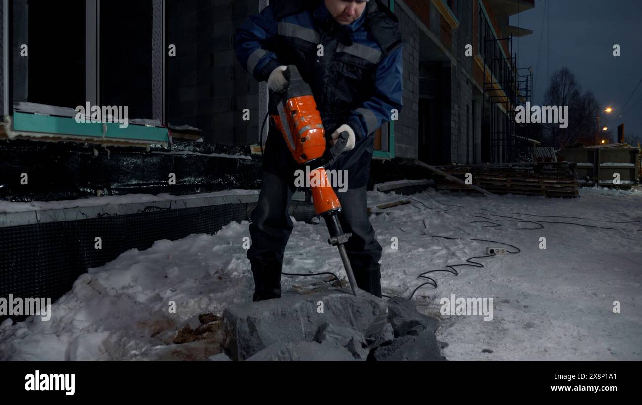 Man drills holes in a concrete block. Clip. Industrial background of a ...
