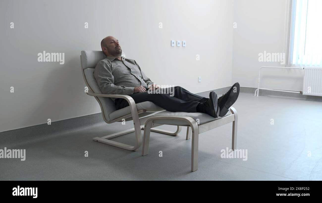 Man is lying in armchair in office. Clip. Man is lying in armchair in ...