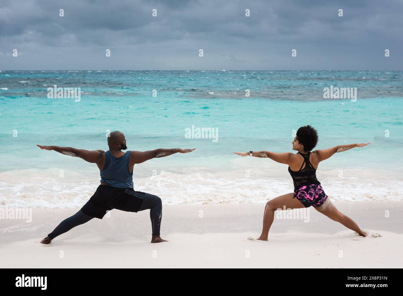 Powerful African American couple doing yoga on the beach in the Abaco ...