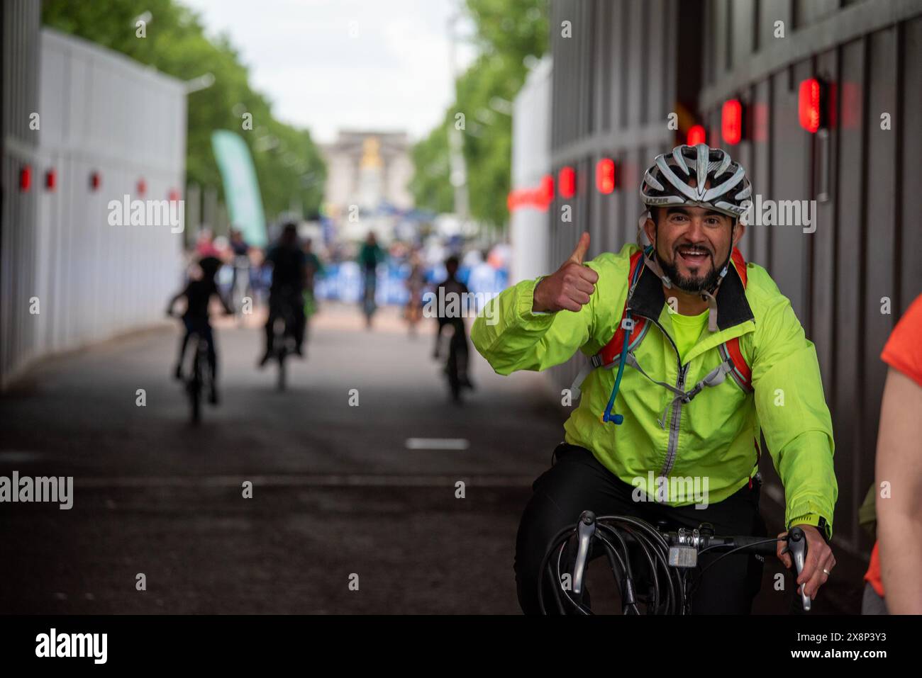 London, UK. 26th May, 2024. A cyclist hold his thumb up while cycling ...