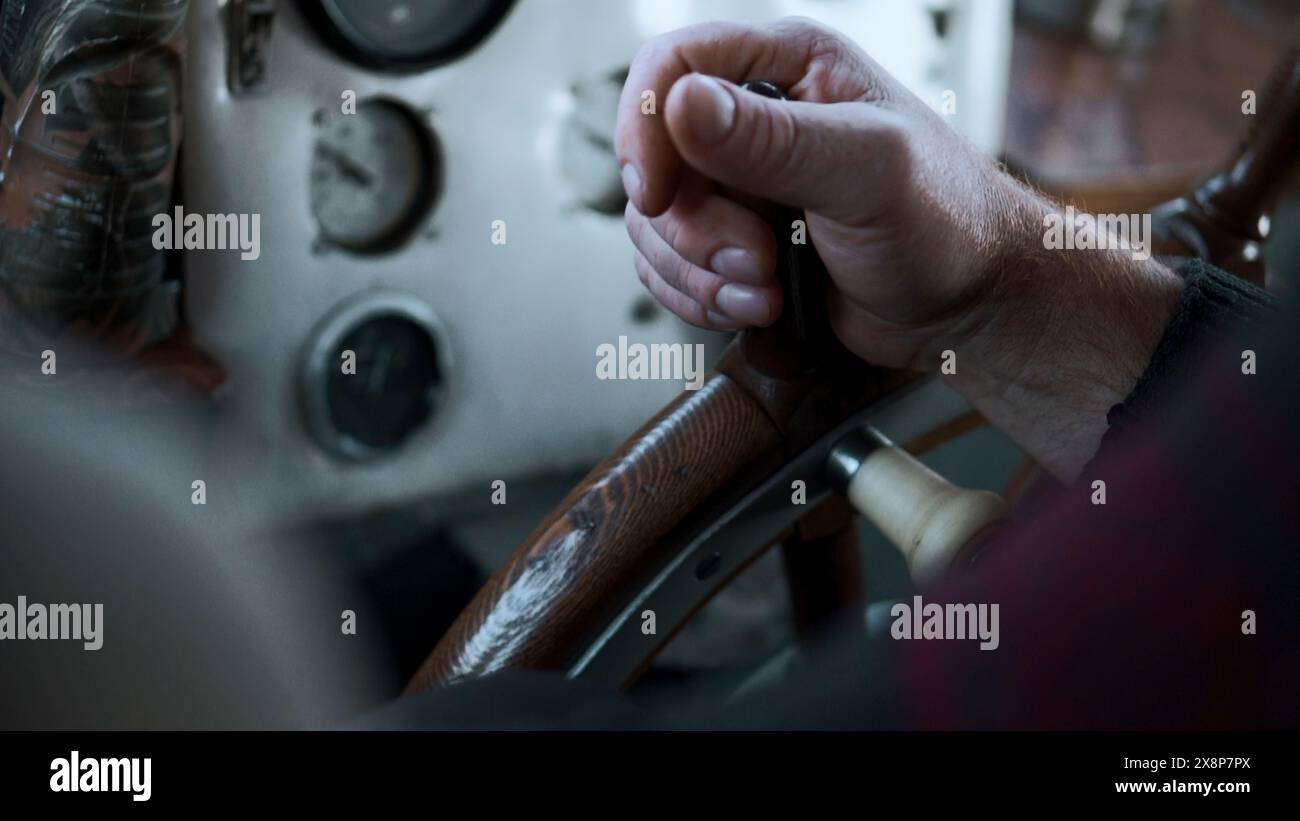 The ship's captain turns the wheel of the ship. Clip. Close up of man ...