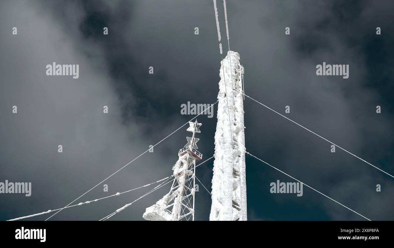 Snow-covered radio tower on background sky. Clip. Frozen structure of ...