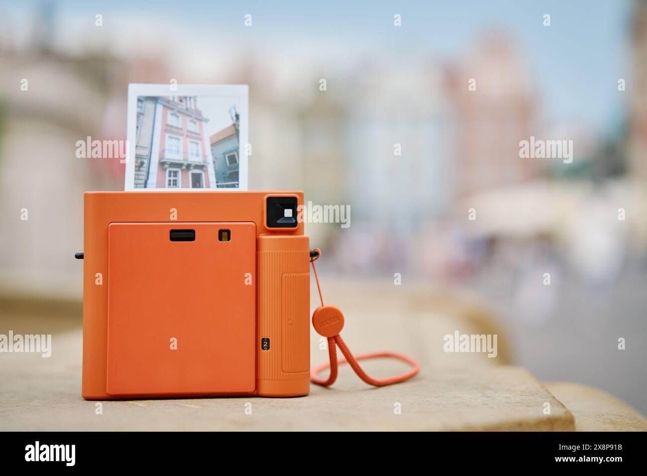 Vintage Orange Instant Camera in city with cloudy sky. Travel shooting ...