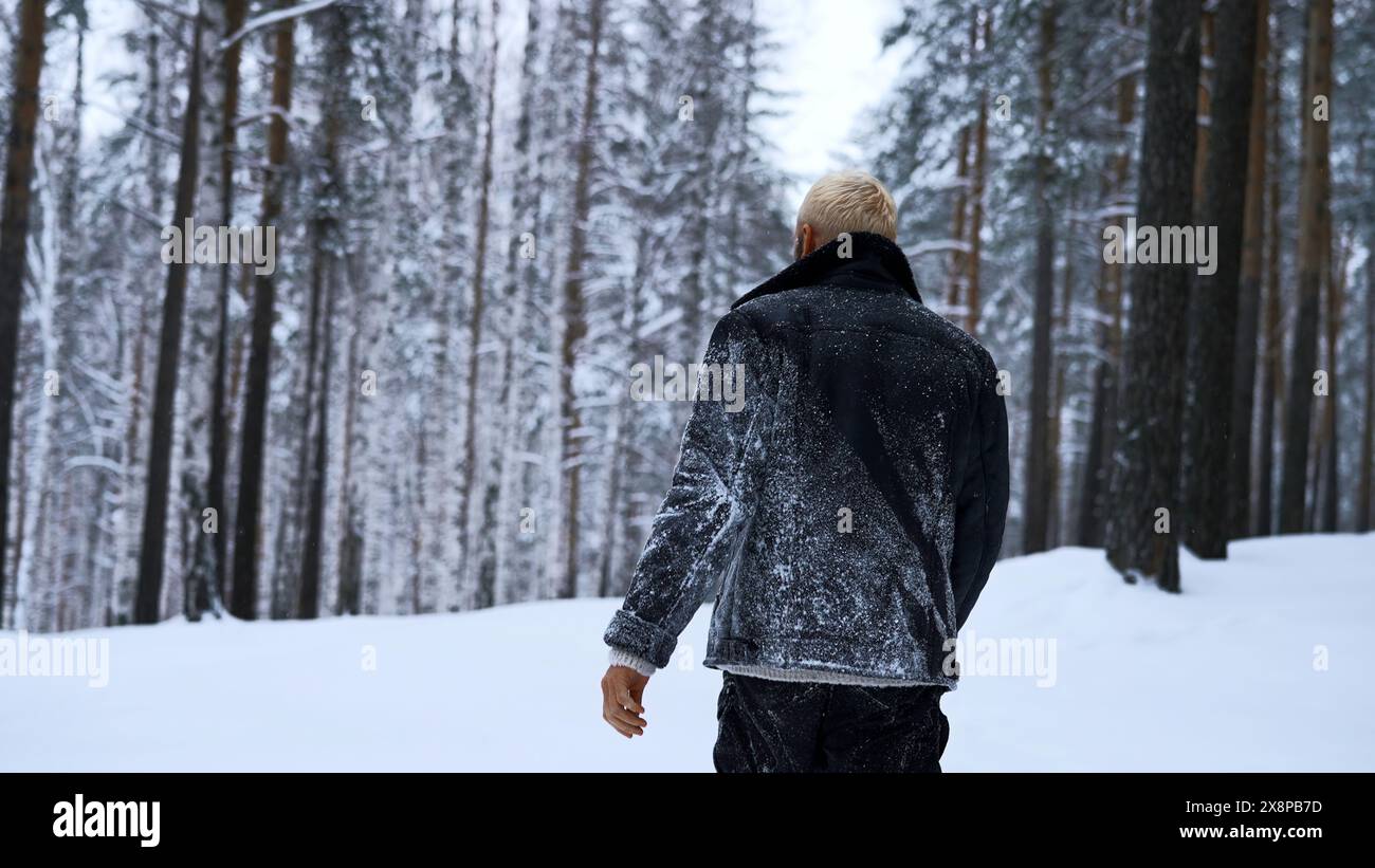 Lone man walking through snow. Media. Young guy with snow on his jacket ...
