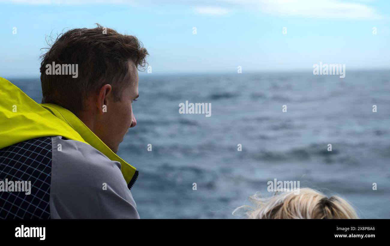 Couple on floating boat on background of sea. Clip. Two people are ...