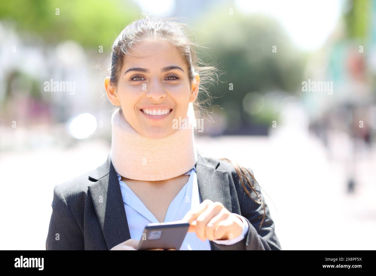 Front view portrait of a happy convelescent executive holding phone ...