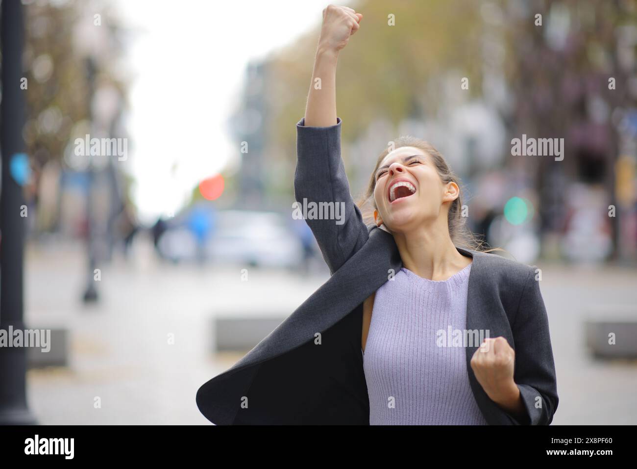 Excited executive celebrating success raising arms in the street Stock ...