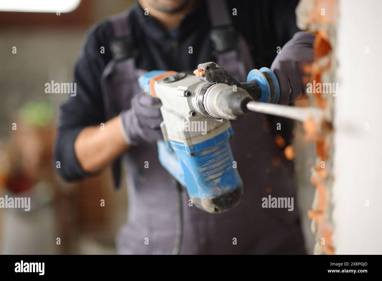 Close up of a construction worker using rotary hammer to wreck wall in ...