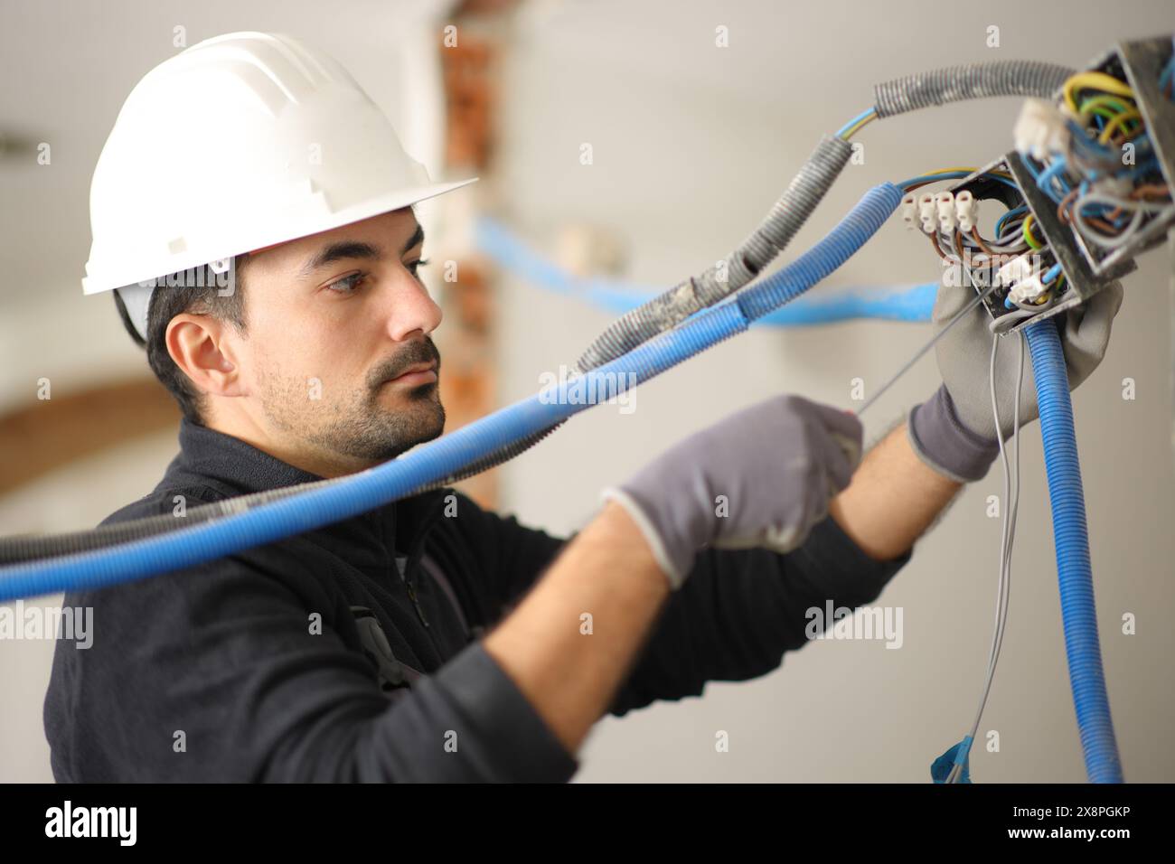 Electrician checking electrical installation using screwdriver in a ...