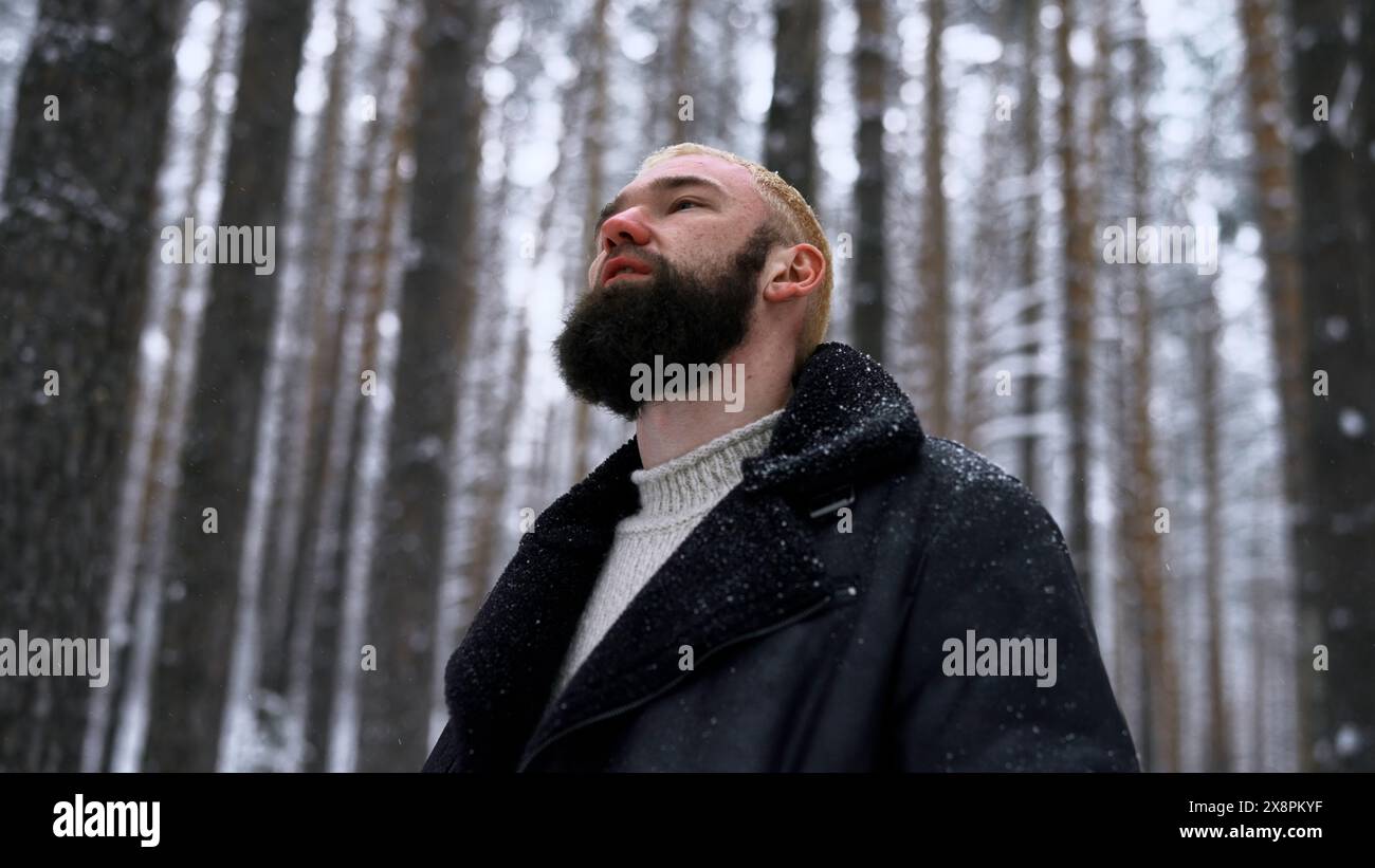Lone man walking through snow. Media. Young guy with snow on his jacket ...
