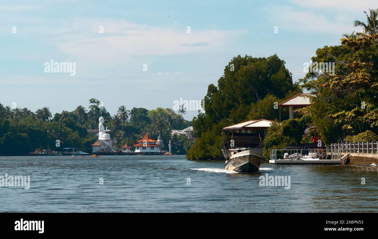 Beautiful river walk with tropical village. Action. River boats ...