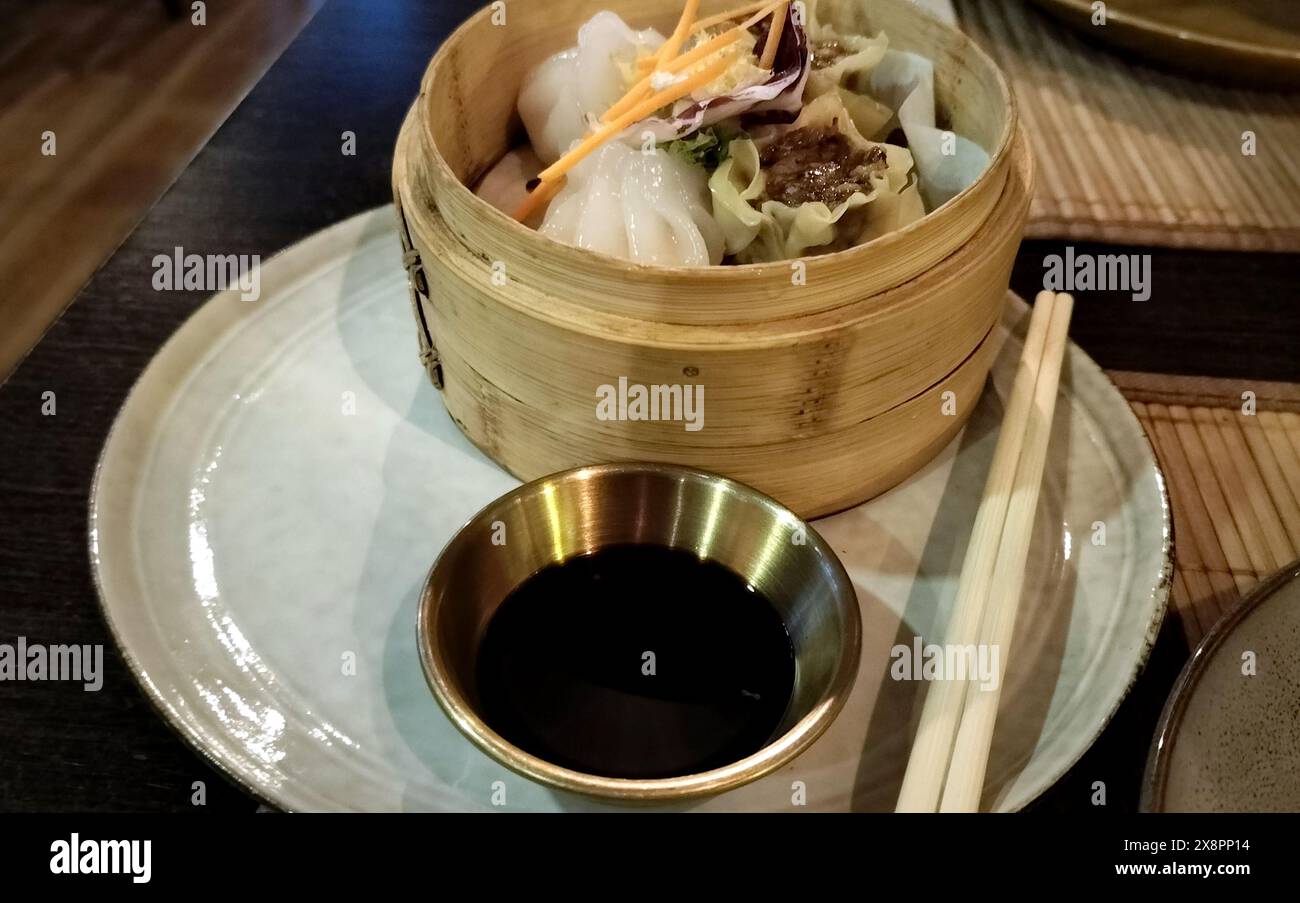 Dim Sum set in bamboo steaming tray, small serving of soy sauce and ...