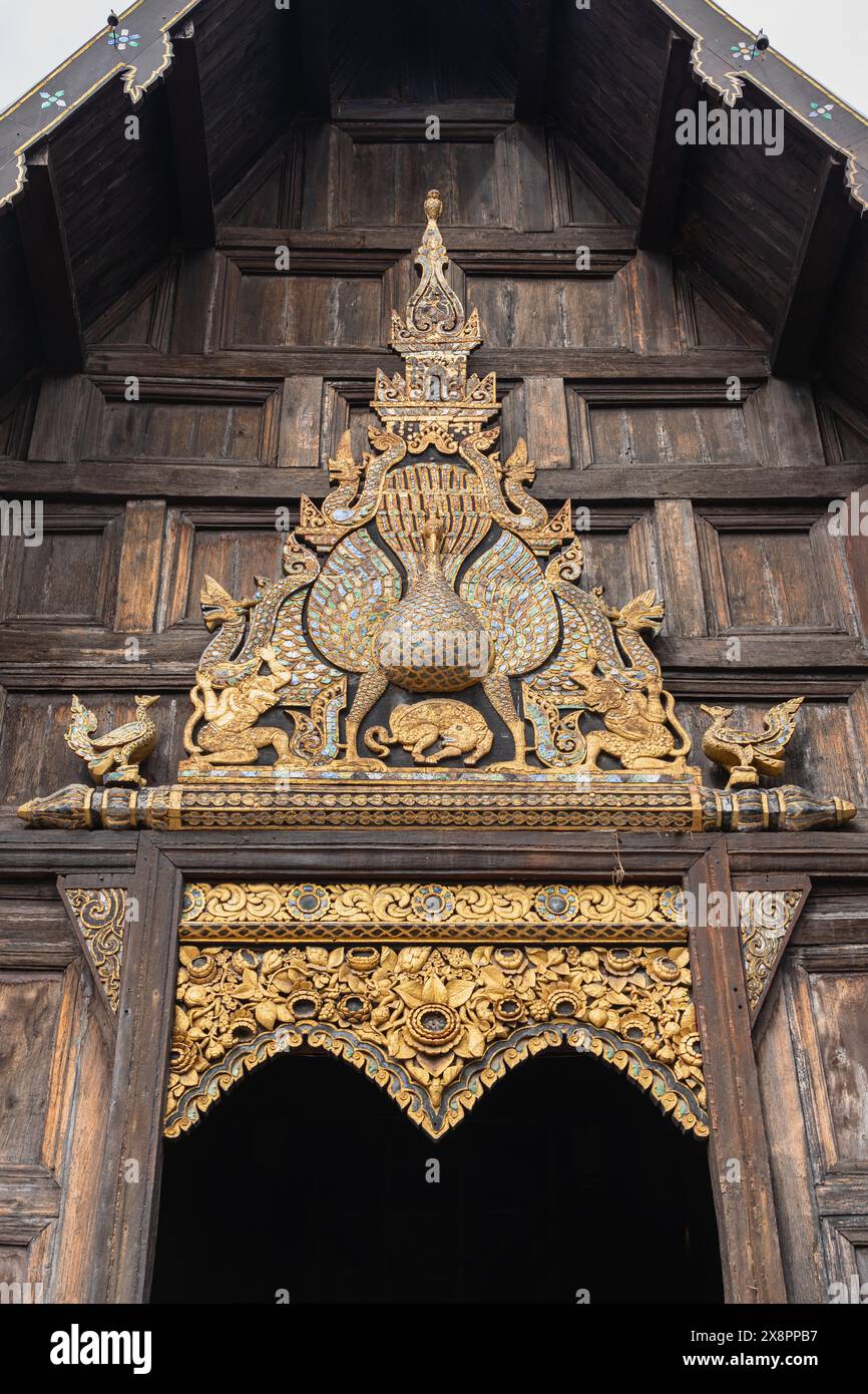 Ancient gilded carved wood panel with peacock above entrance to ...